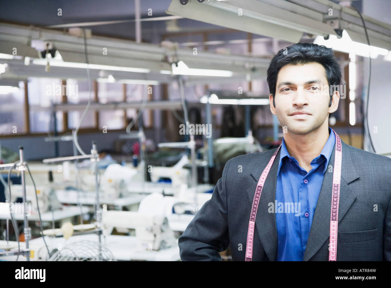 Portrait of a male fashion designer standing in a textile industry ...