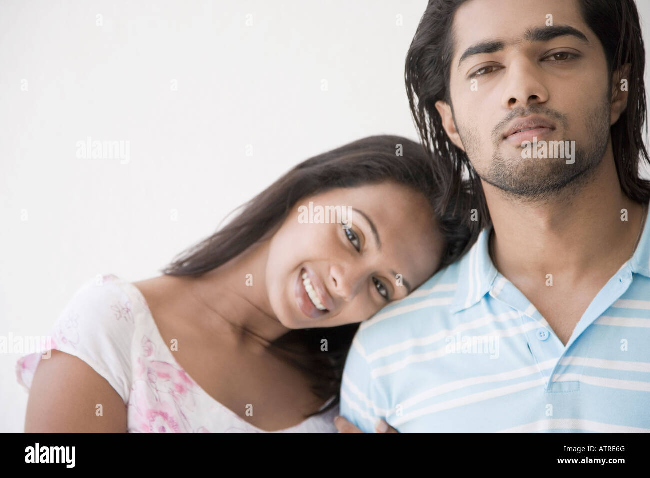 Portrait of a young woman resting her head on a young man's shoulder ...