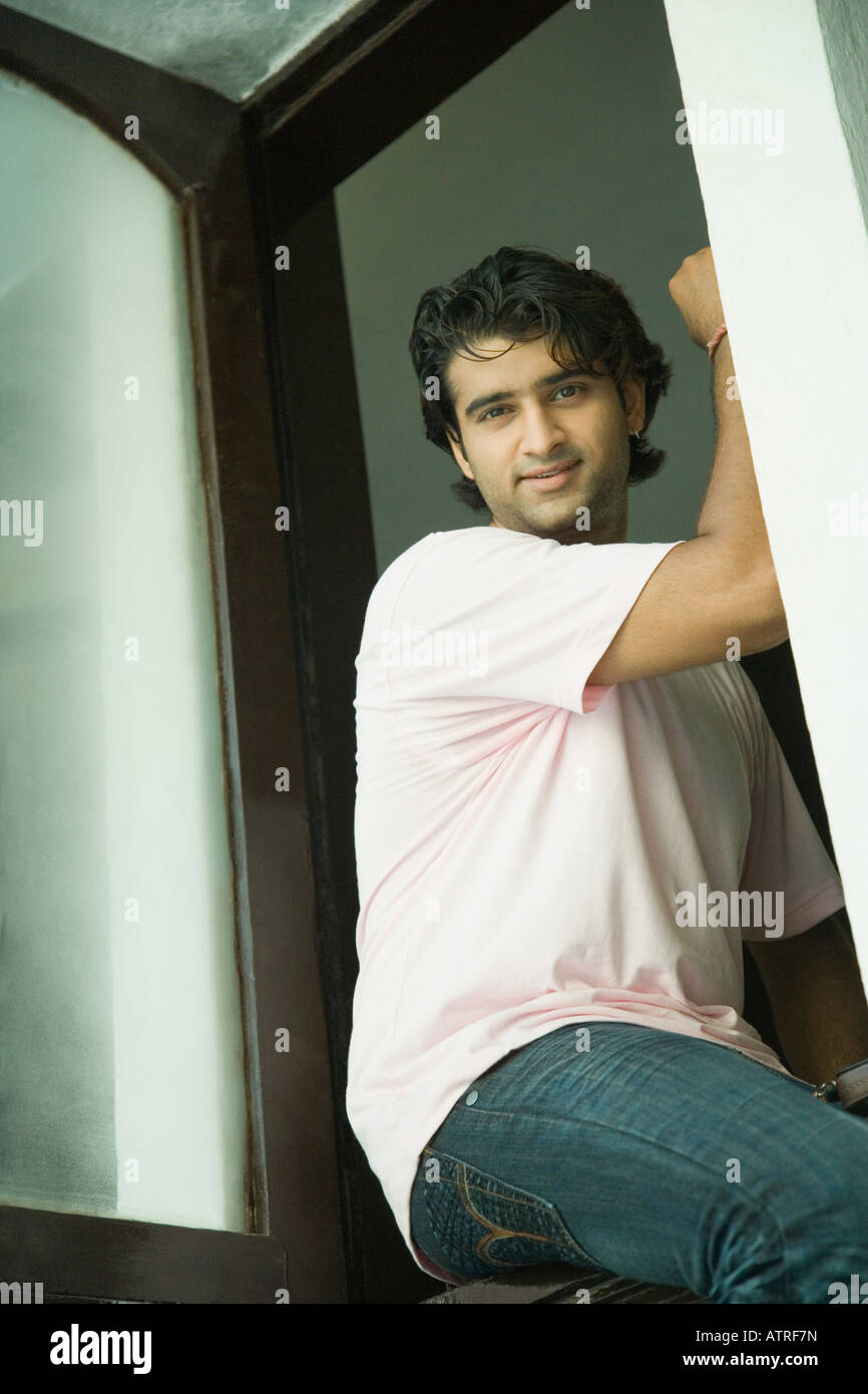 Young man sitting at a window Stock Photo - Alamy