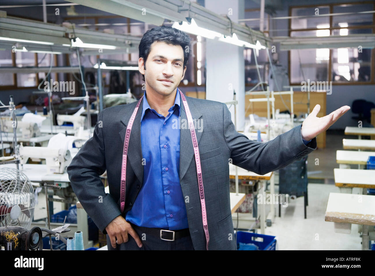 Portrait of a male fashion designer standing in a textile industry ...