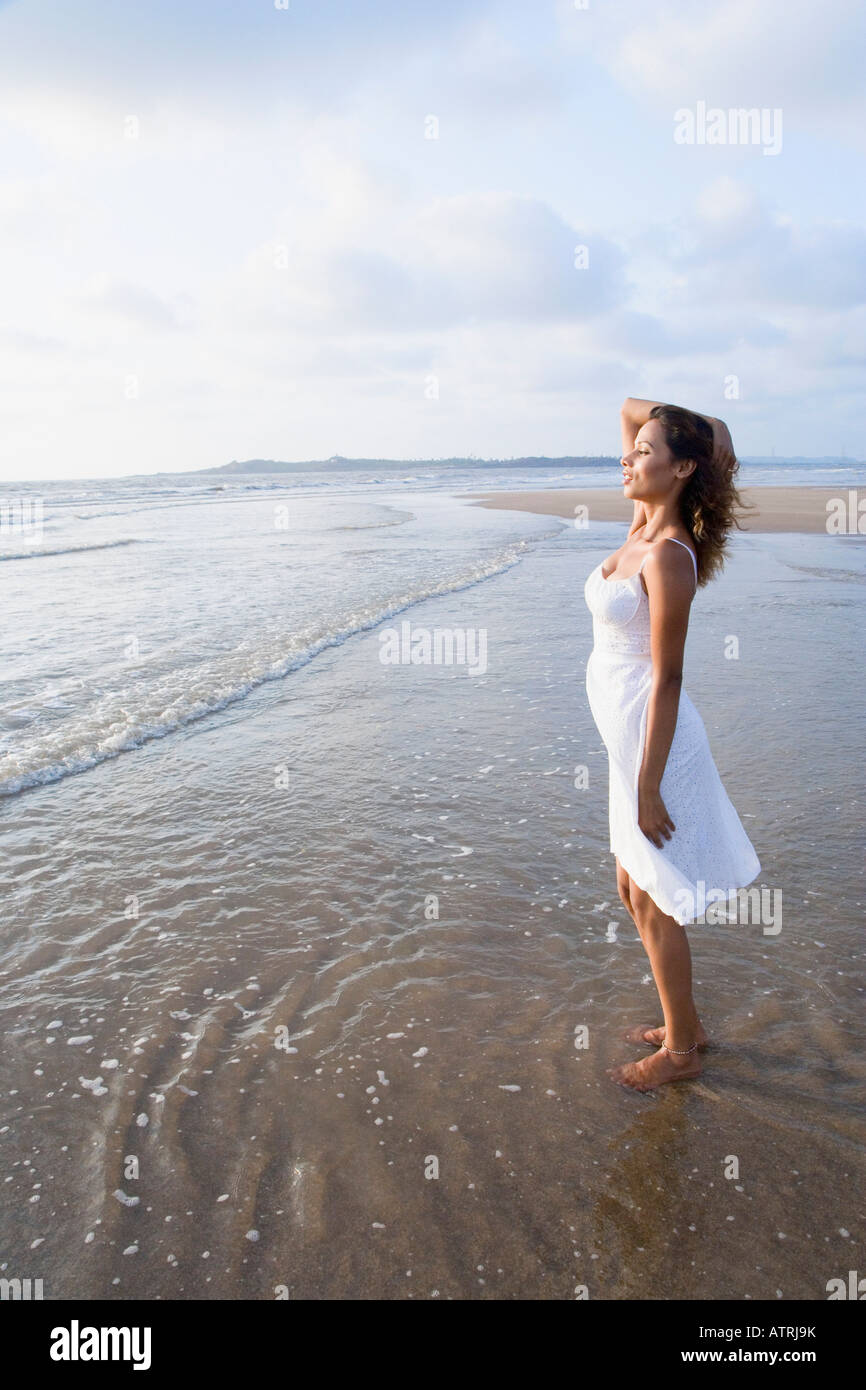 Side profile of a young woman standing on the beach Stock Photo - Alamy