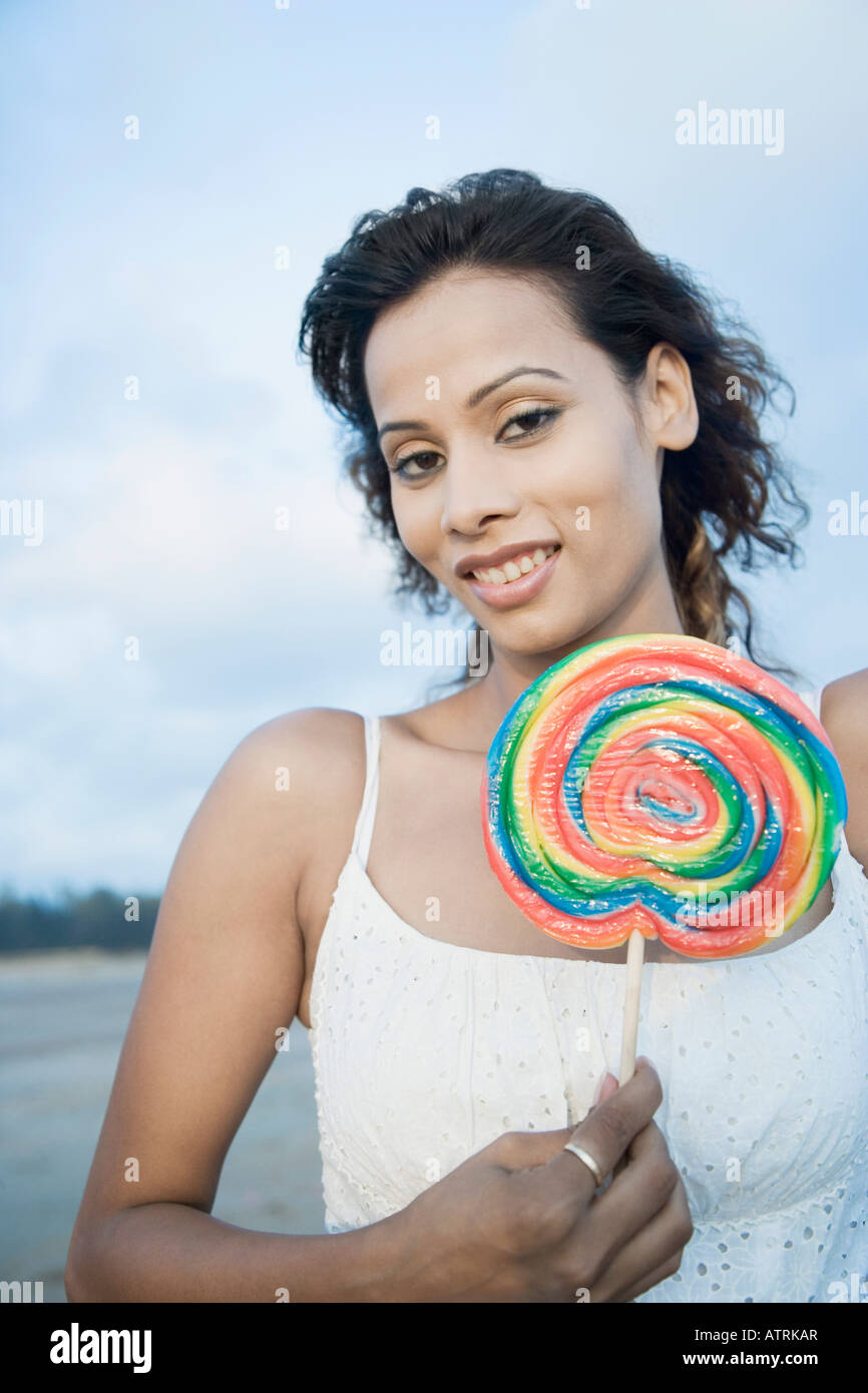 Portrait of a young woman holding a candy and smiling Stock Photo - Alamy