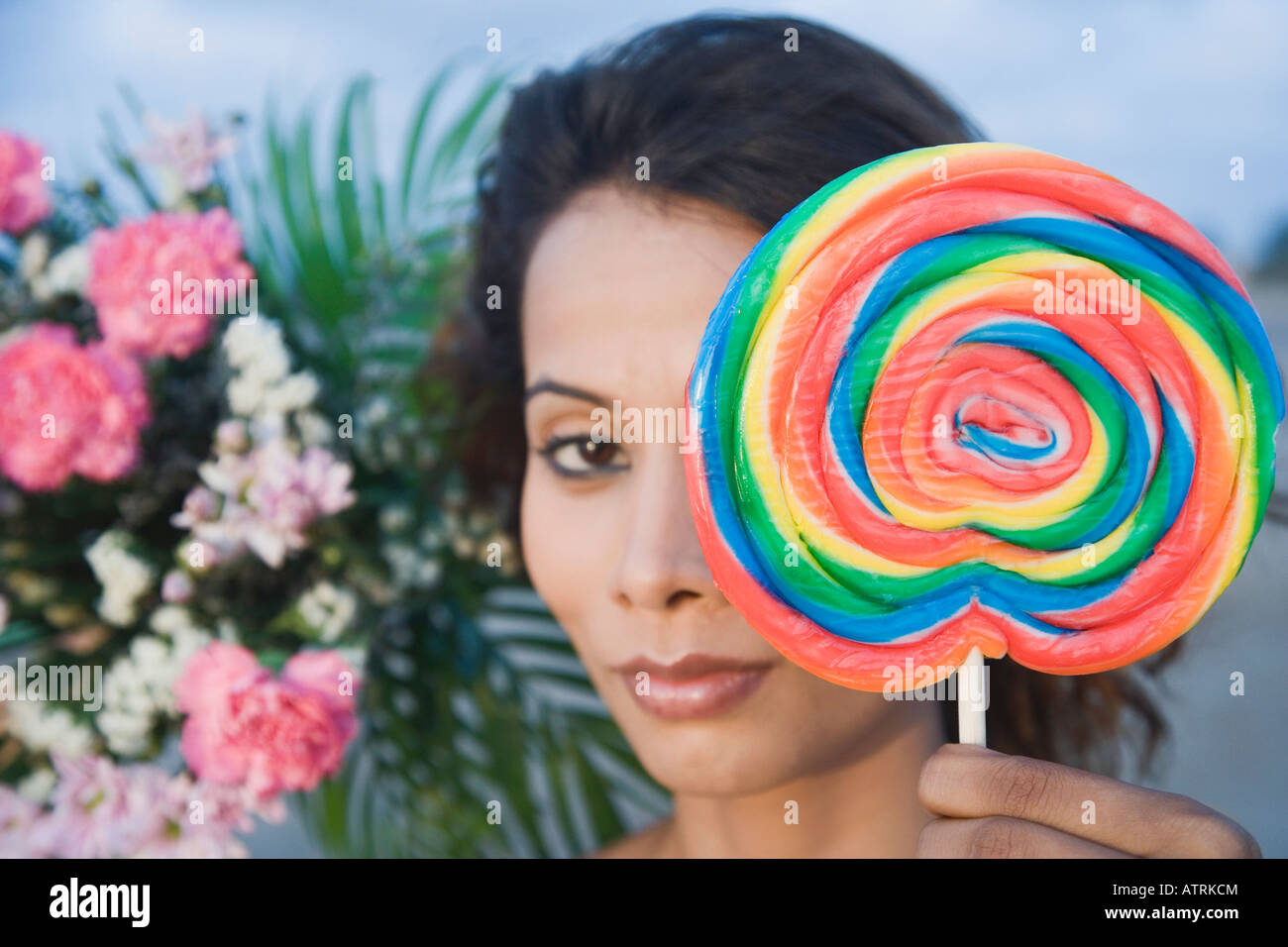 Portrait of a young woman holding a candy Stock Photo - Alamy