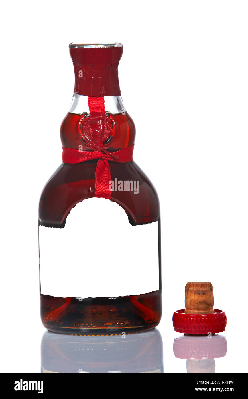 A vintage brandy bottle opened and the cork reflected on white ...