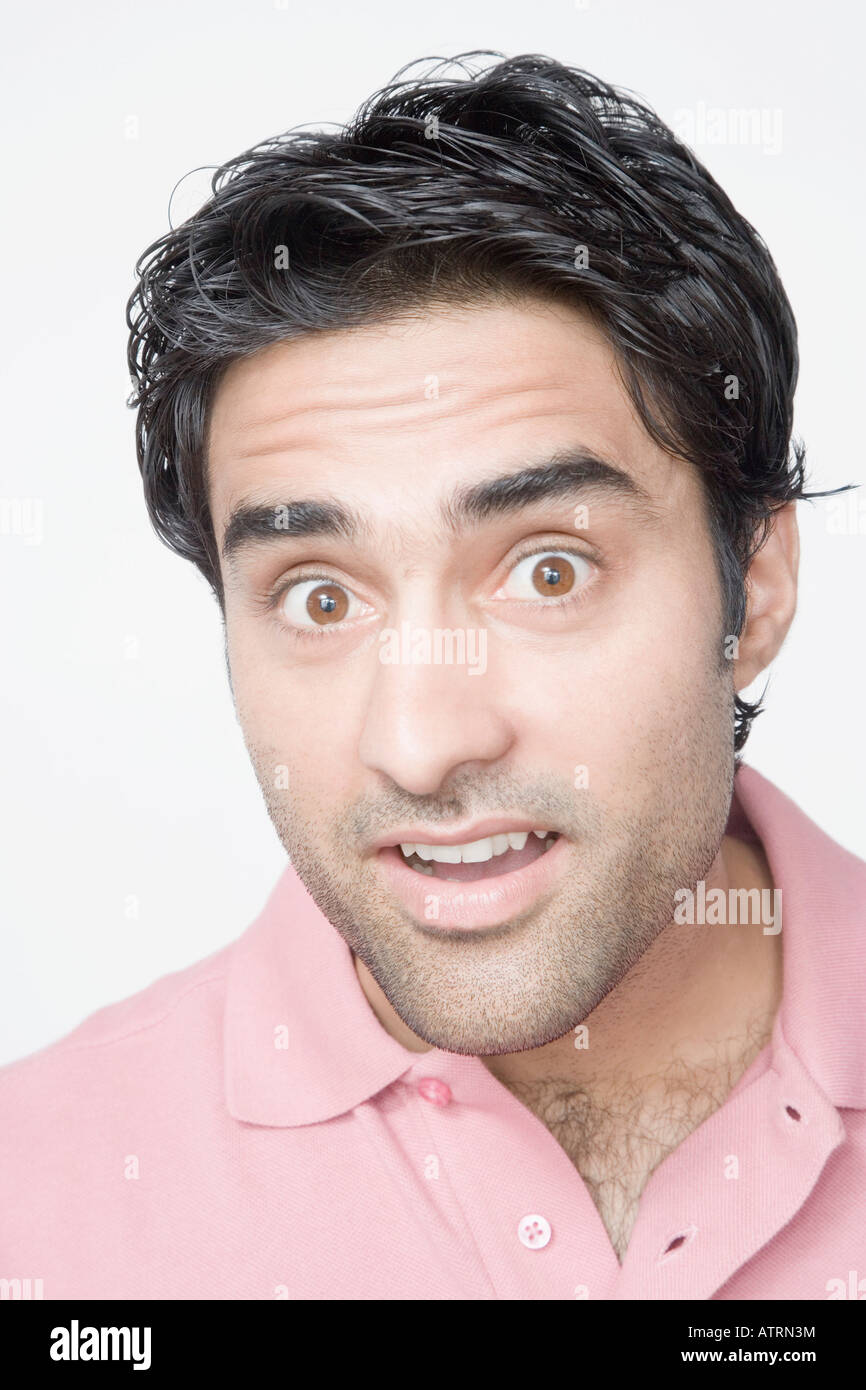 Portrait of a young man looking surprised Stock Photo - Alamy