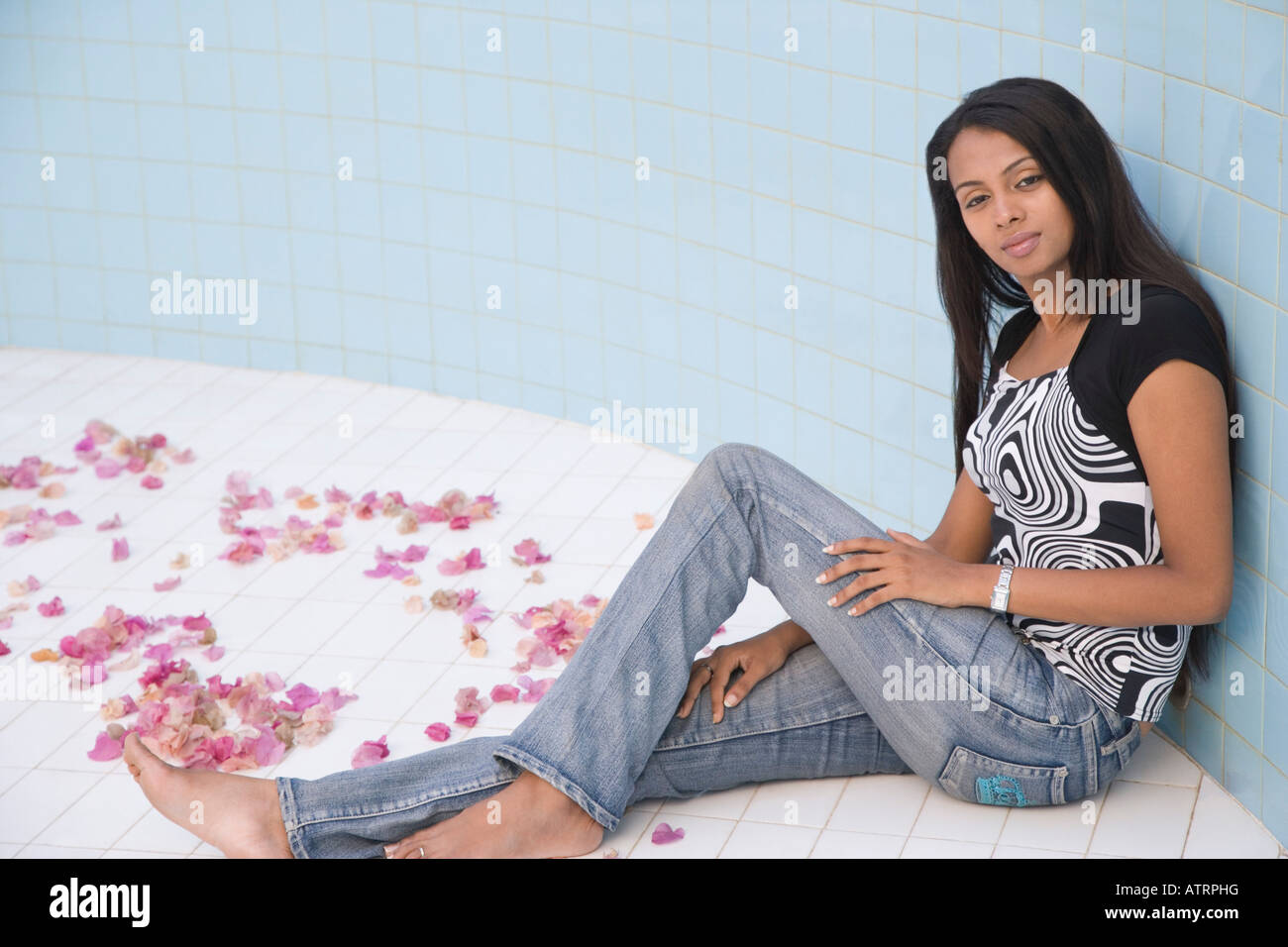Portrait of a young woman sitting in an empty swimming pool Stock Photo ...