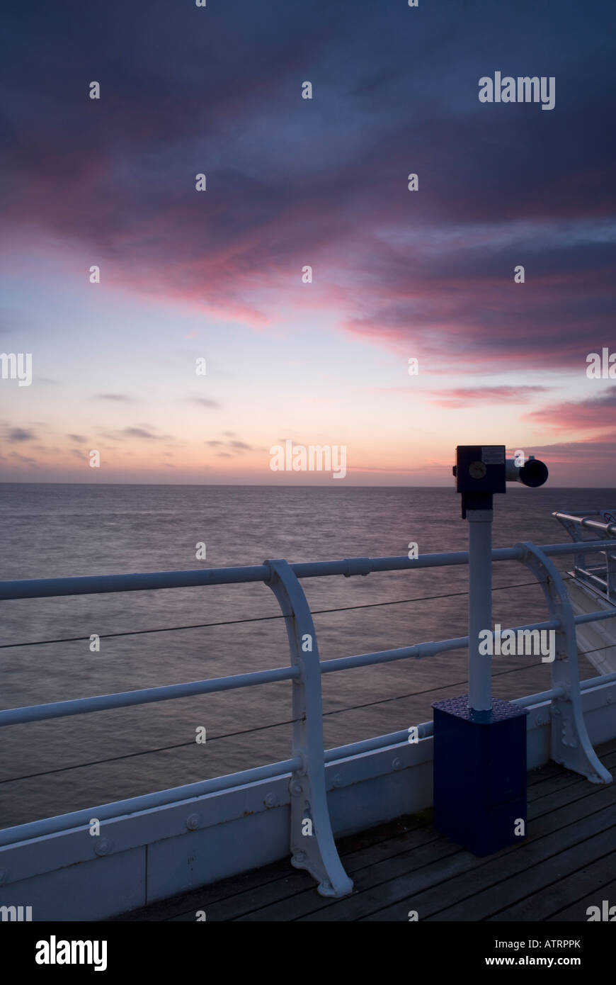 Telescope on a pier looking out to sea after sunset, Cromer, Norfolk ...