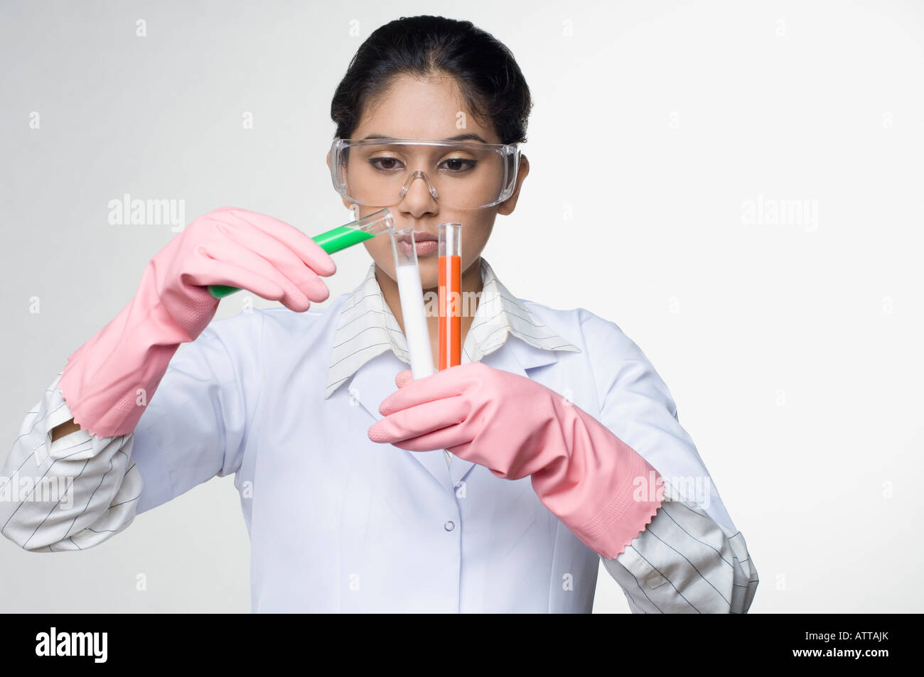 Female scientist pouring liquid from a test tube into another test tube ...