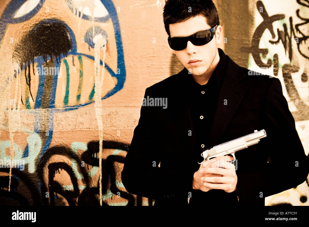 Male model performing secret agent with gun Stock Photo - Alamy