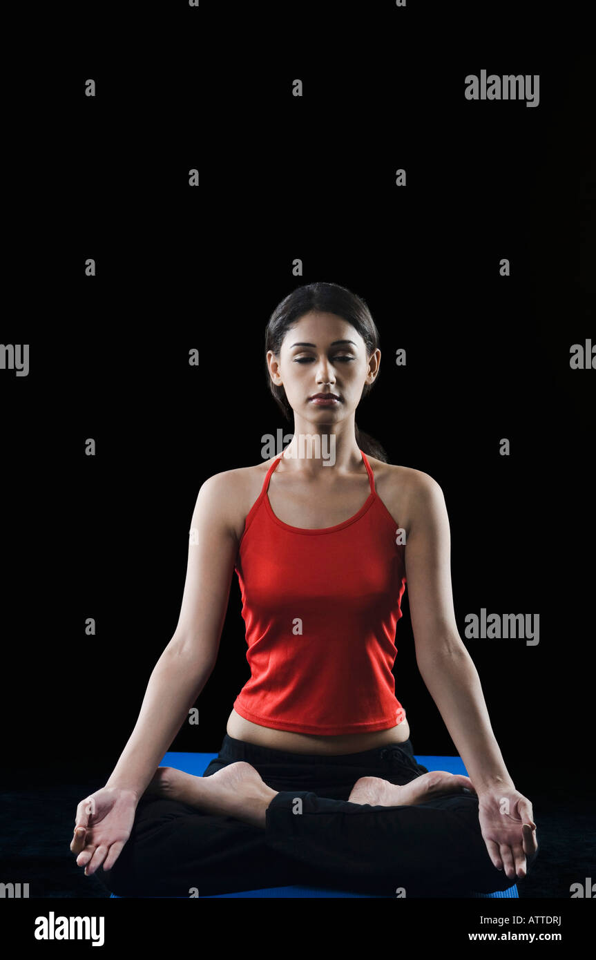 Young woman meditating in lotus position Stock Photo - Alamy