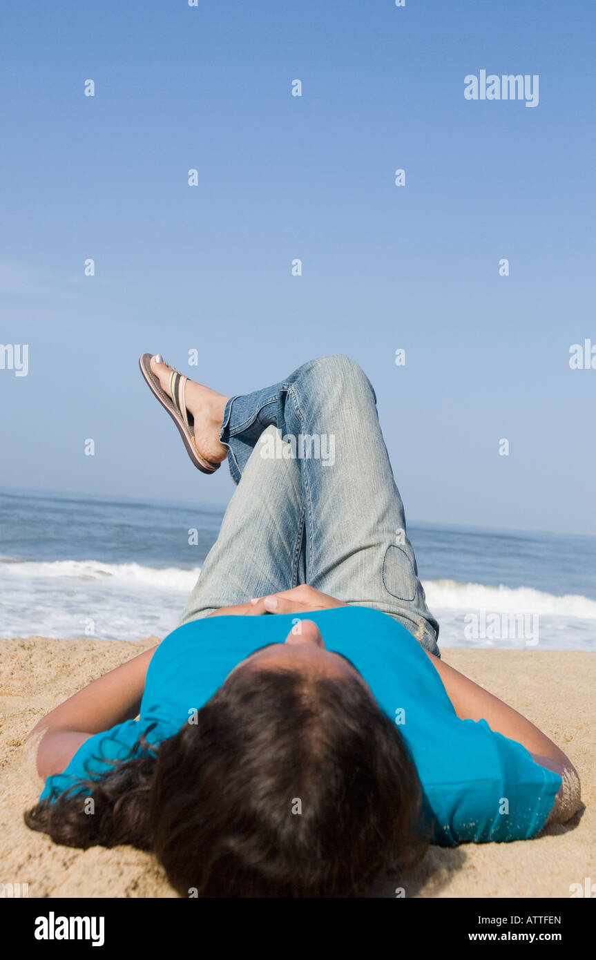 Young woman lying on the beach Stock Photo - Alamy