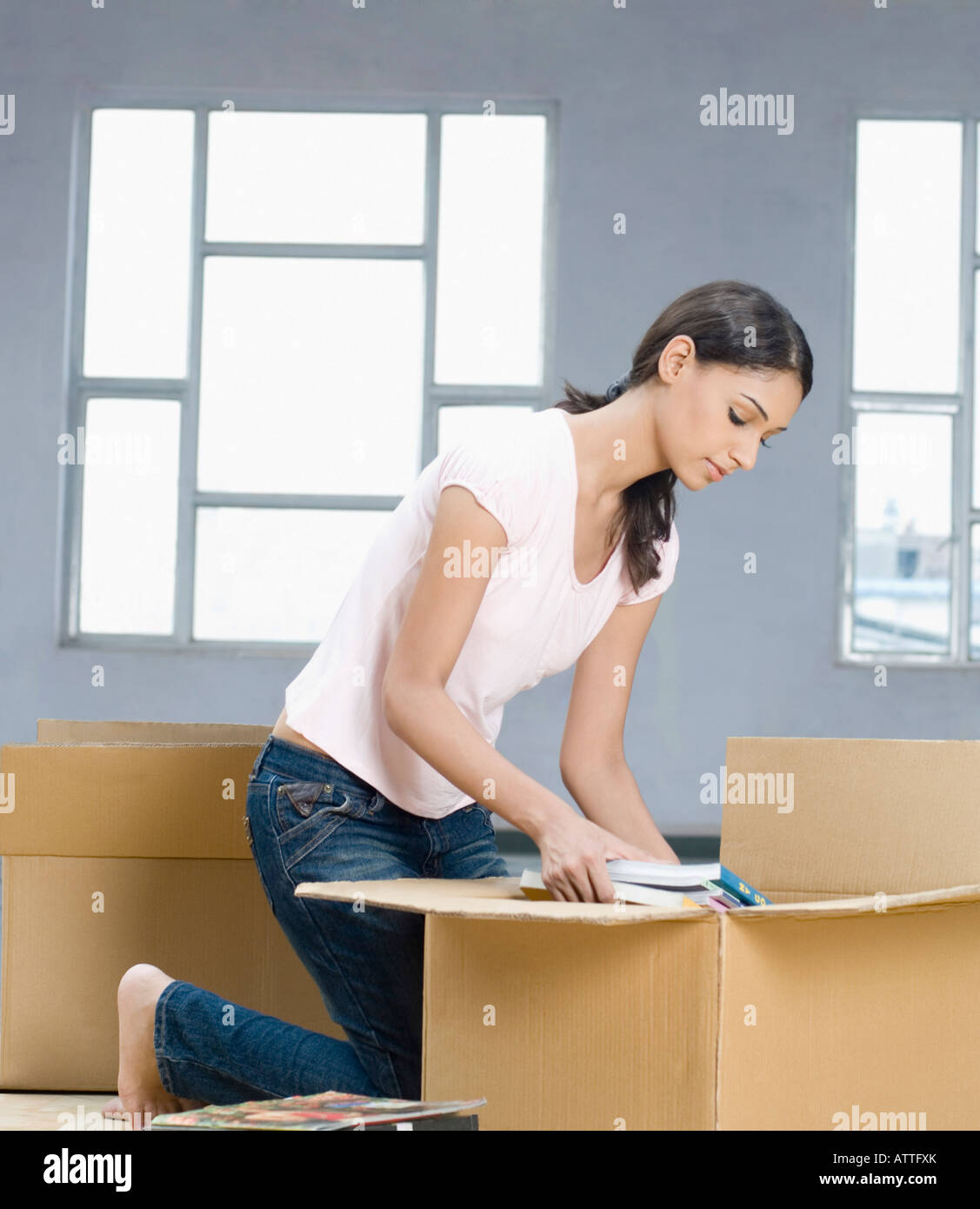 Side profile of a young woman packing a cardboard box Stock Photo - Alamy