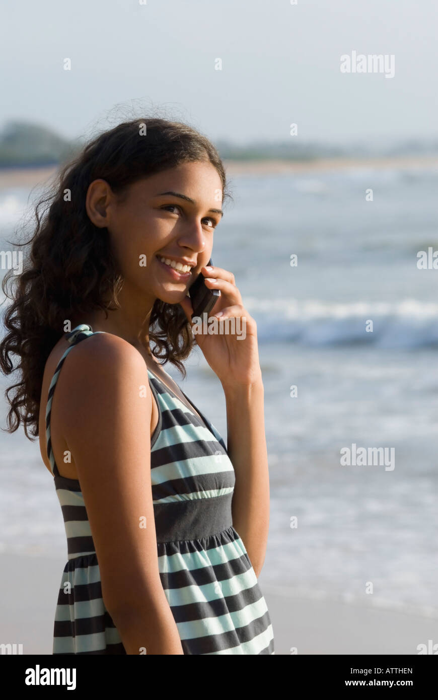 Side profile of a young woman talking on a mobile phone and smiling ...