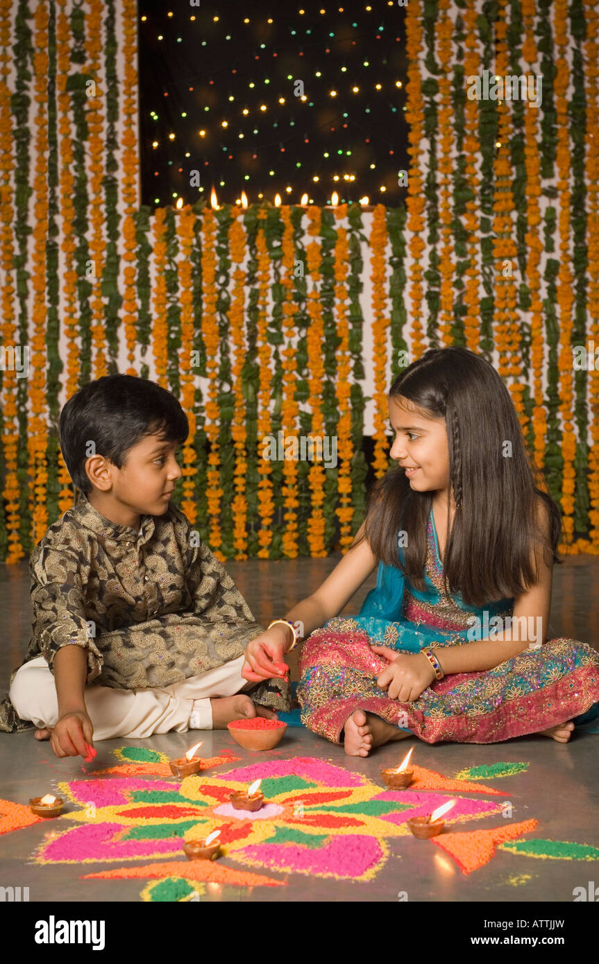 Boy and his sister making rangoli Stock Photo - Alamy