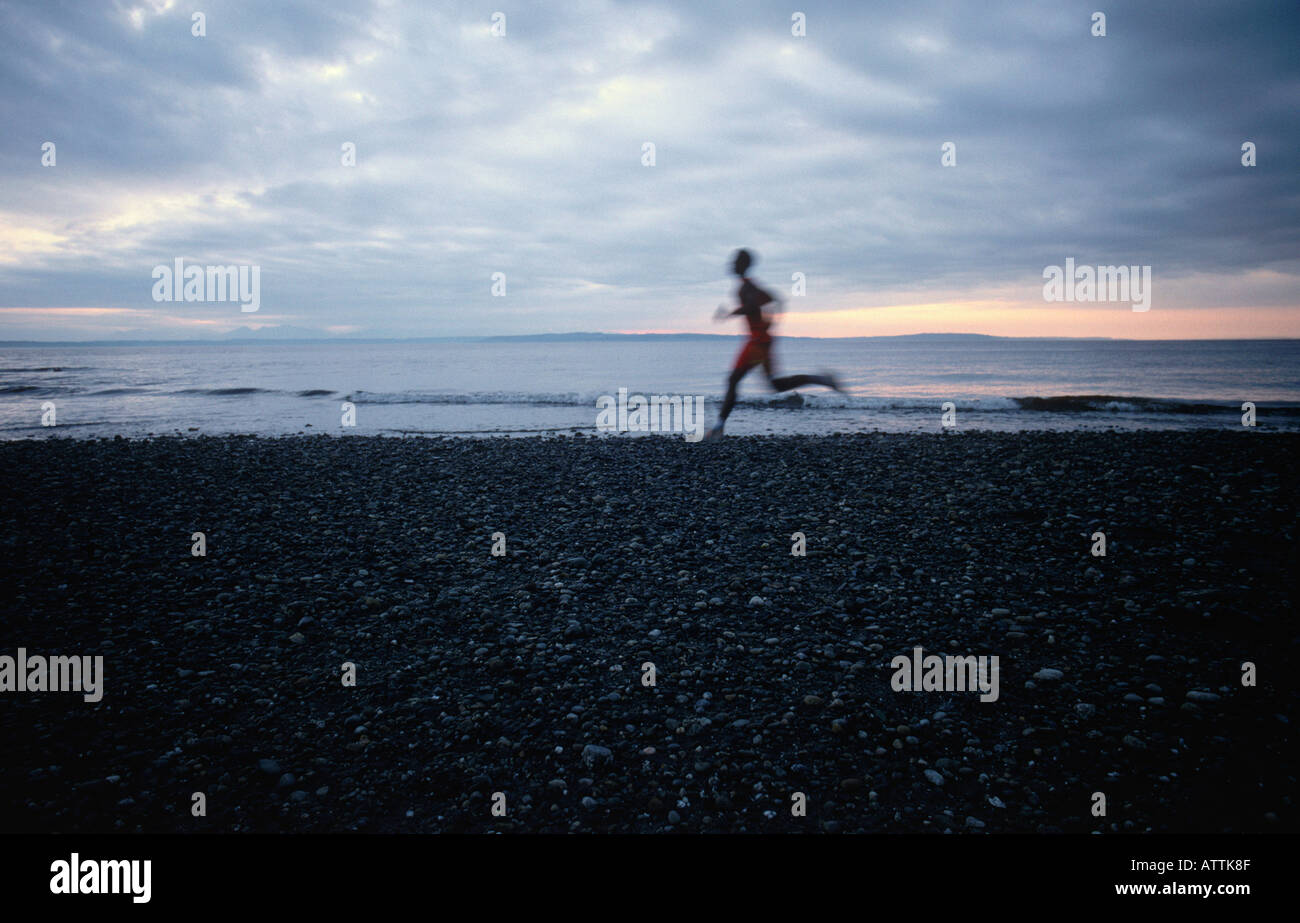 Man running at sunset on beach Washington USA Stock Photo - Alamy