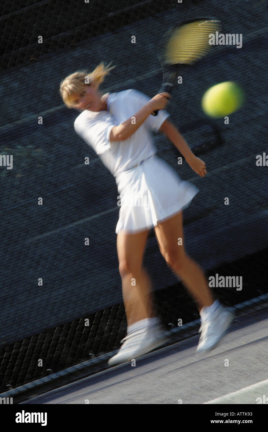 Young woman hitting a tennis ball Stock Photo - Alamy