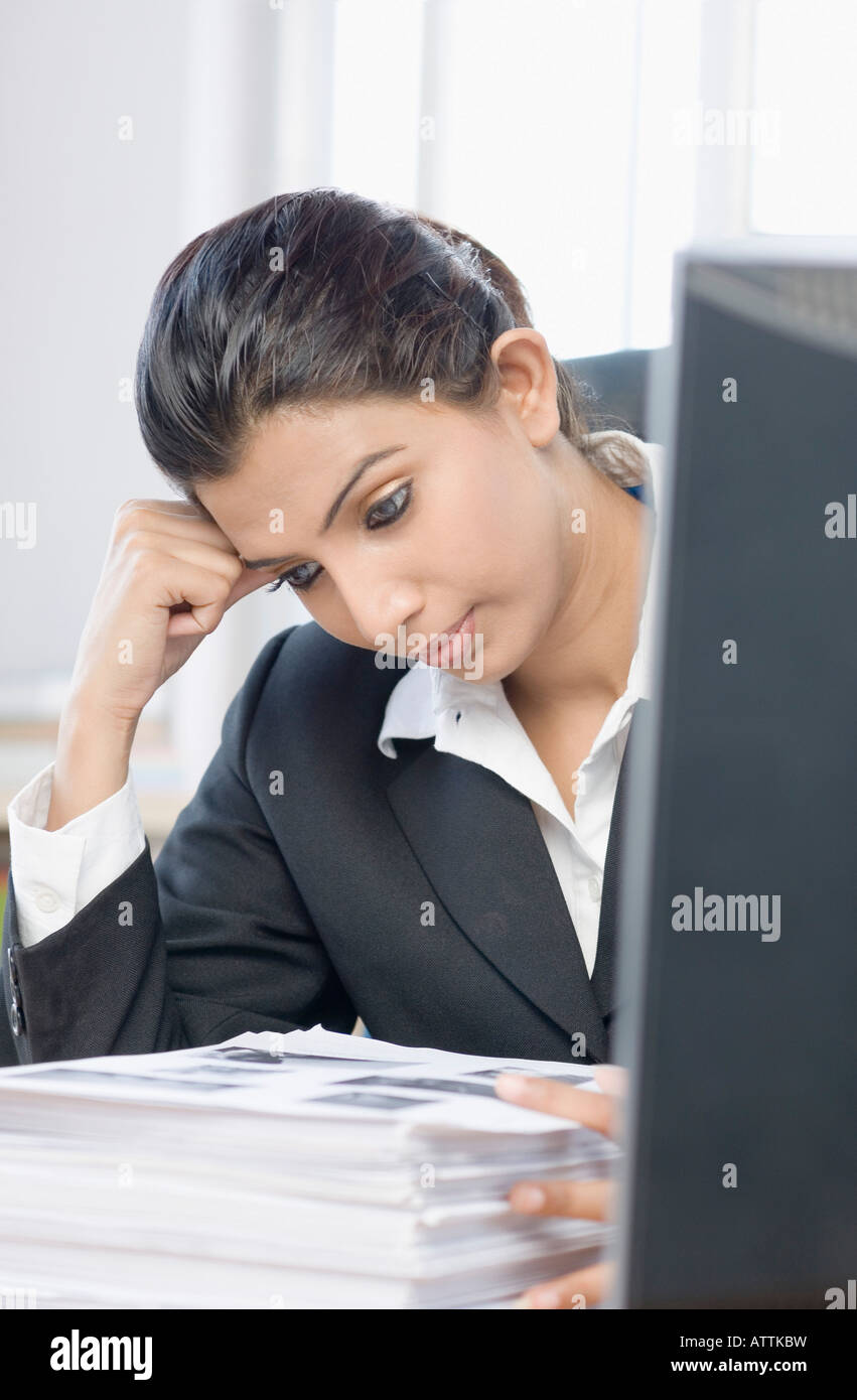 Businesswoman sitting at a table and thinking Stock Photo - Alamy