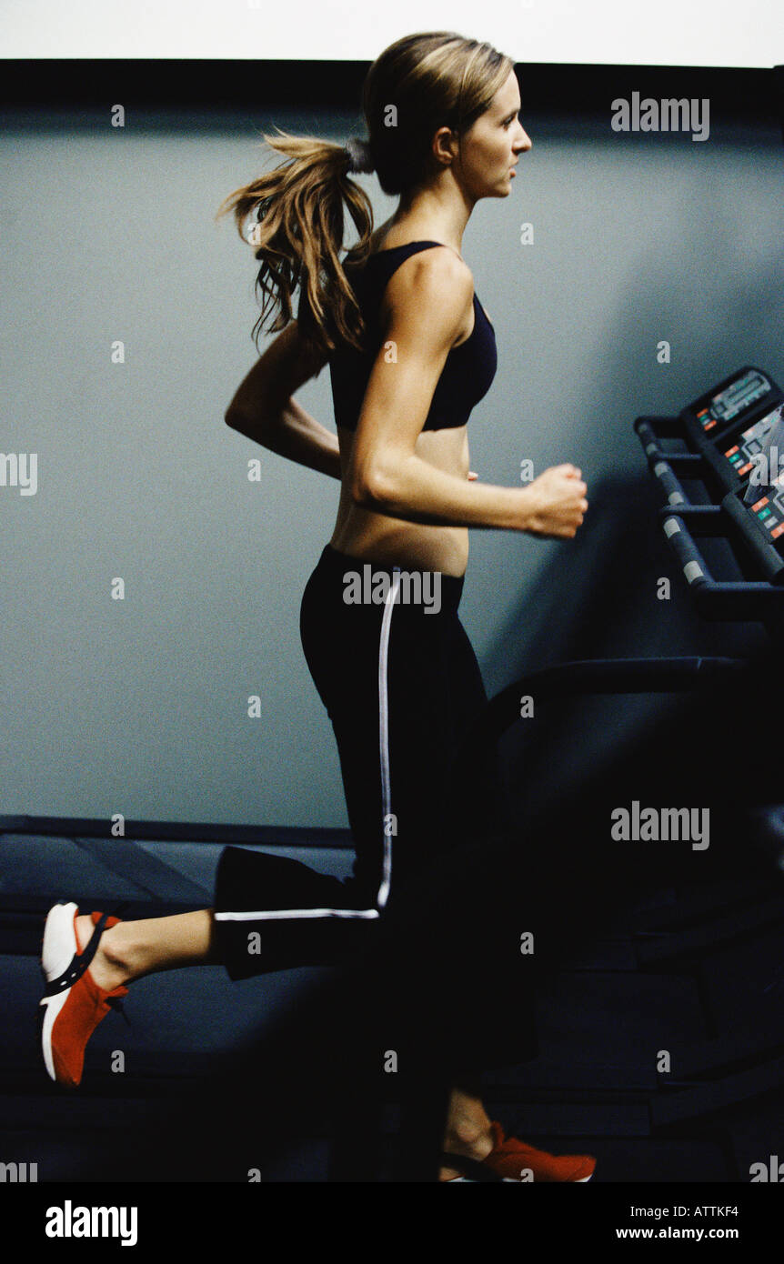 Woman running on treadmill Stock Photo - Alamy