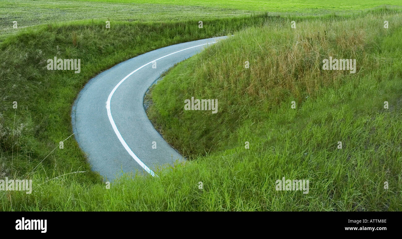 ROAD FIELD WINDING ONE LANE ASPHALT ROAD CURVES BETWEEN GREEN AND DRIED ...