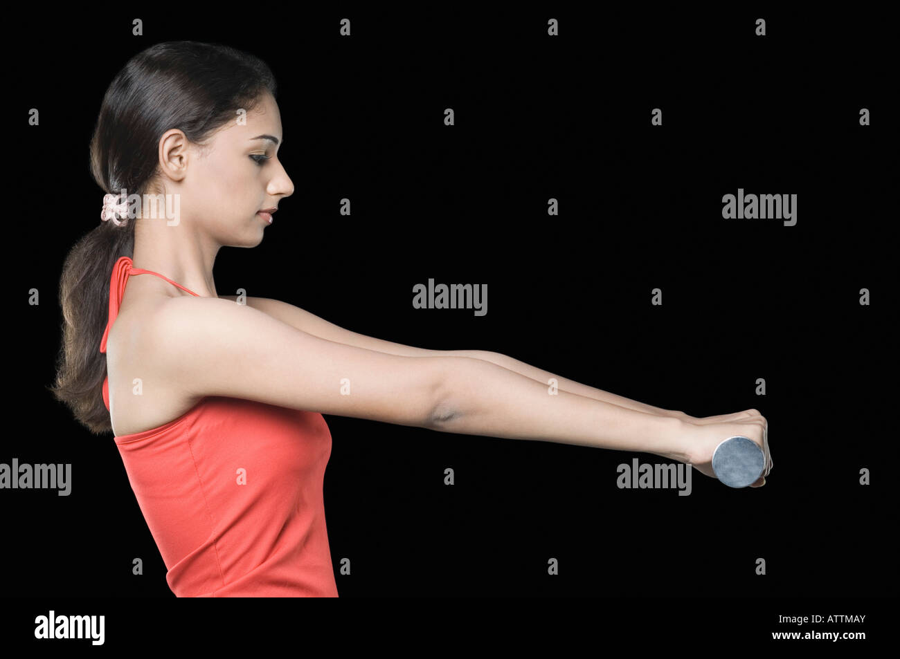 Side profile of a young woman exercising with a dumbbell Stock Photo ...