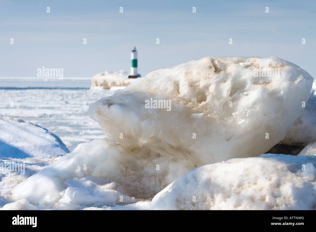 Large chunk of ice and snow with Lake Michigan and a green channel ...
