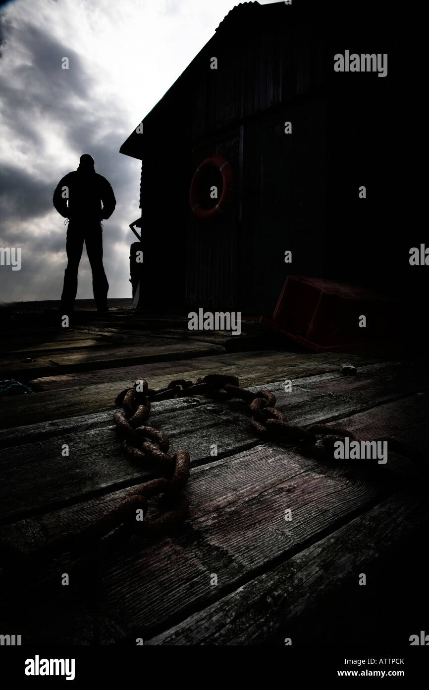 man standing next to old shack Stock Photo - Alamy