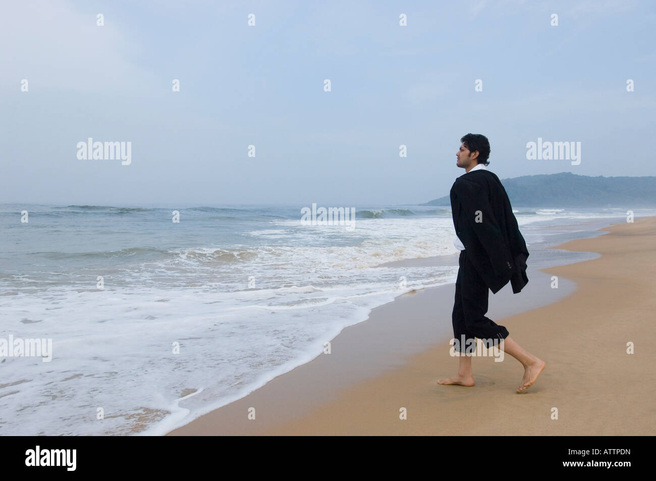 Side profile of a businessman walking on the beach Stock Photo - Alamy