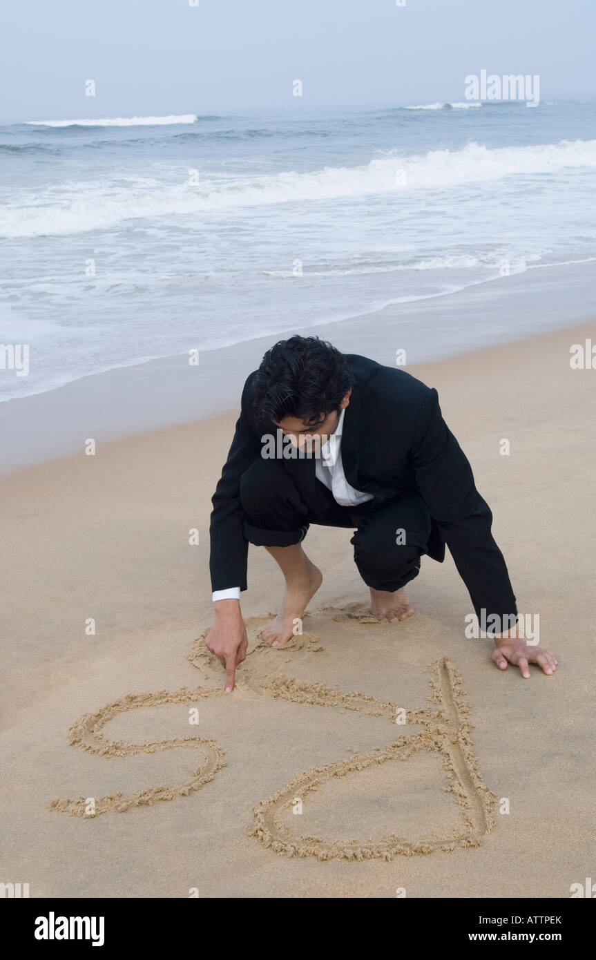 Businessman writing in sand on the beach Stock Photo - Alamy