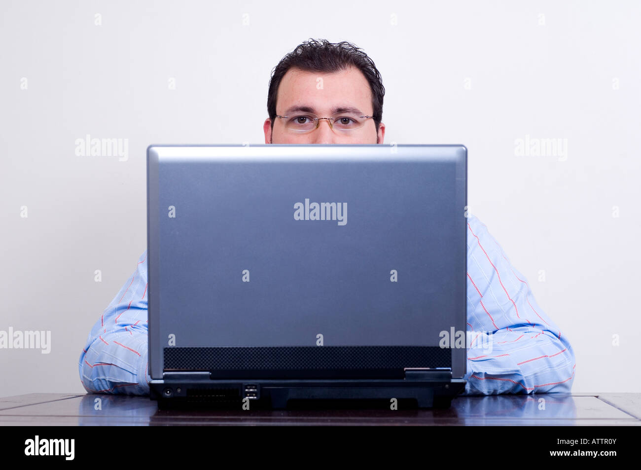 Man peeking from behind laptop Stock Photo - Alamy