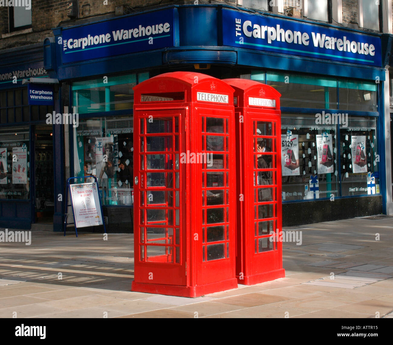 Phone boxes incongruously sited beside a shop selling the mobile phones ...