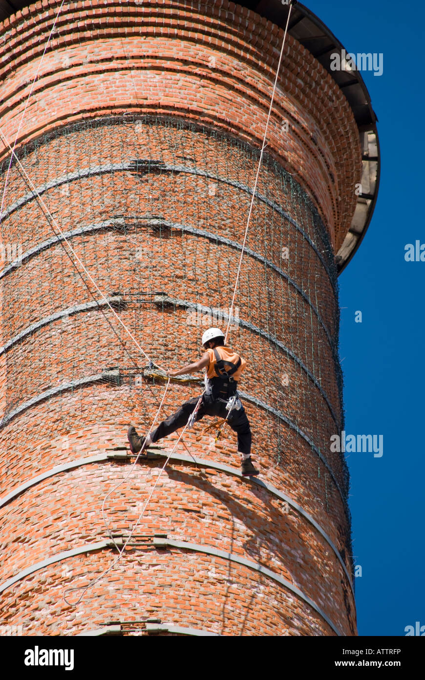 Cropped shot of an unrecognizable worker hanging from a high industrial ...