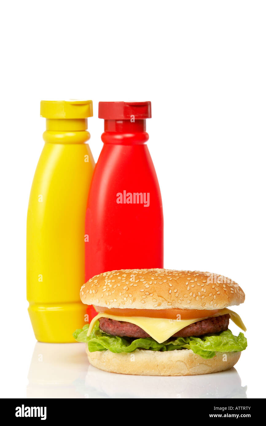Cheeseburger with mustard and ketchup bottles reflected on white ...
