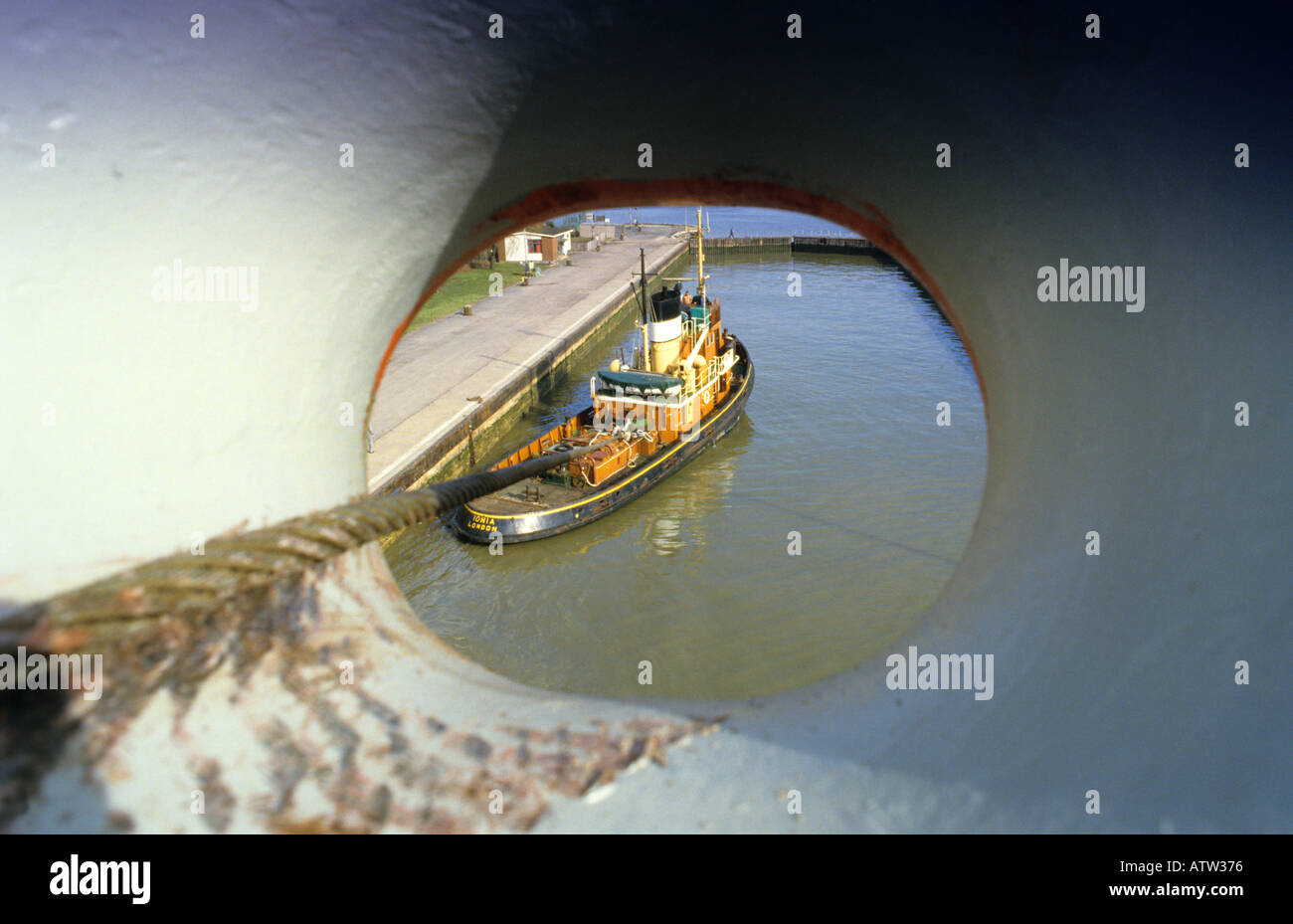 View through Anchor hawser port hole showing tug boat in harbour ...