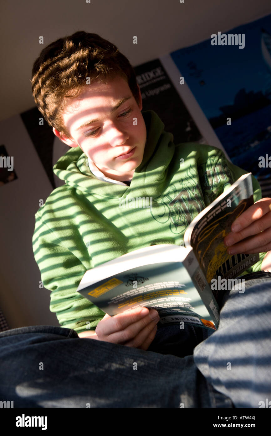 teenage boy reading a novel in his bedroom Stock Photo - Alamy