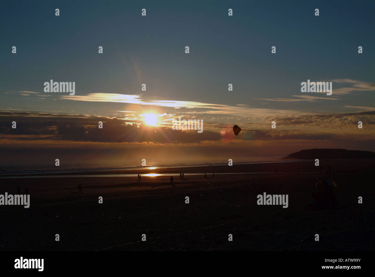 People playing on a beach as the sun is setting in the summer Stock ...