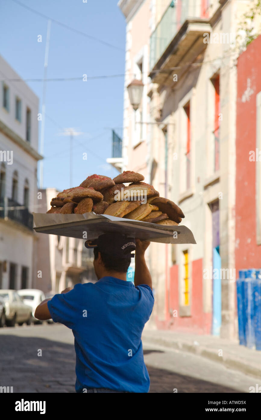 MEXICO Guanajuato Adult man walking down street carrying tray of breads ...