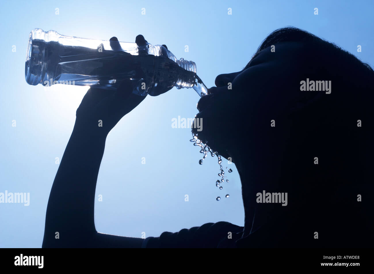 Young asian woman drinking refreshing water in Silhouette on a sunny ...