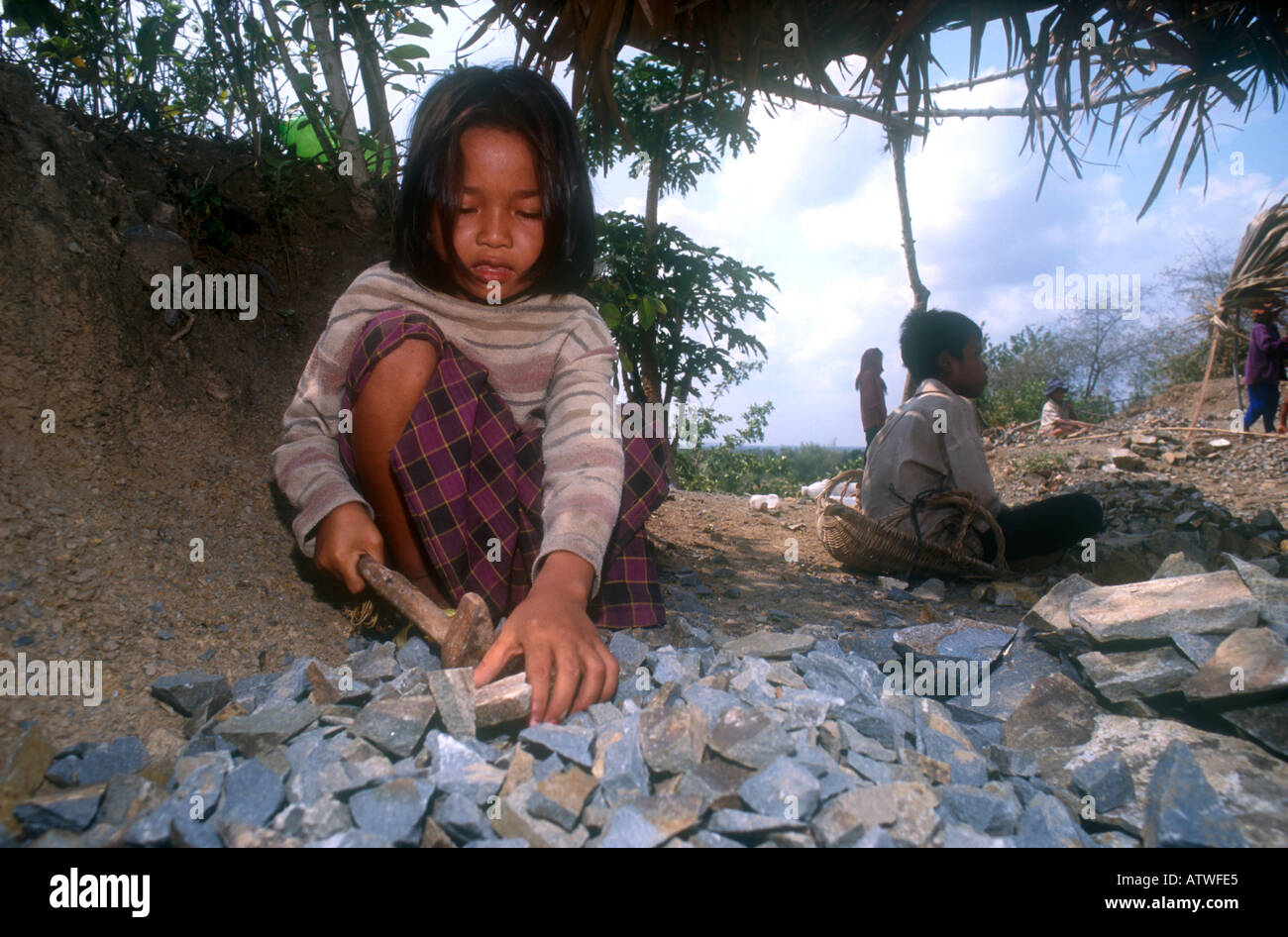 Child labourers work in a quarry breaking stones to build roads. Takeo ...