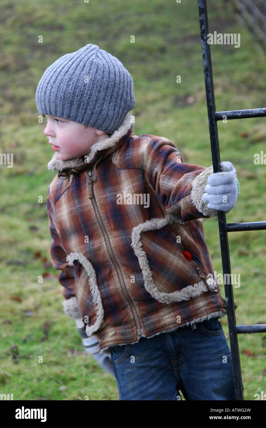 A young small boy holding open a gate for someone to walk through Stock ...