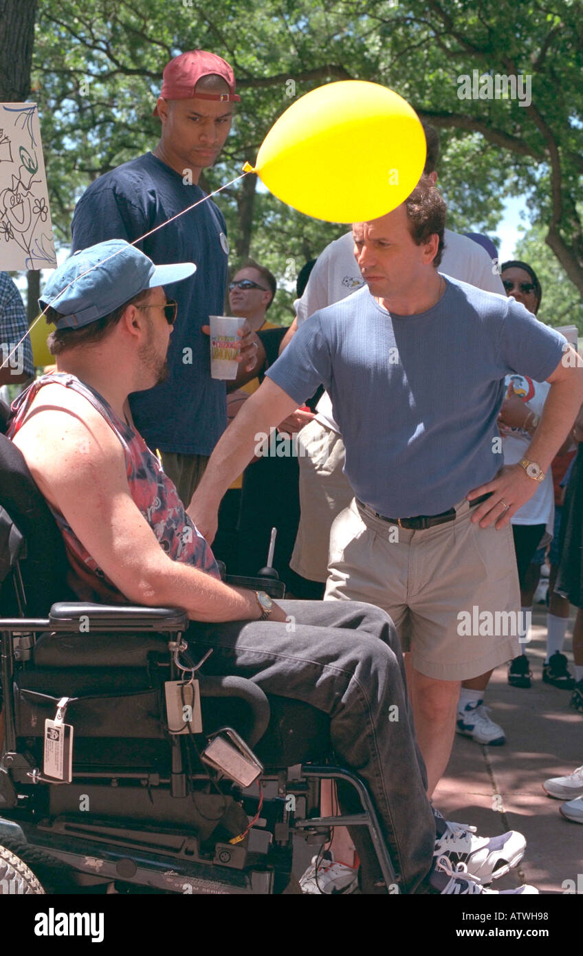 Senator Paul Wellstone talking with handicapped man in wheelchair age ...