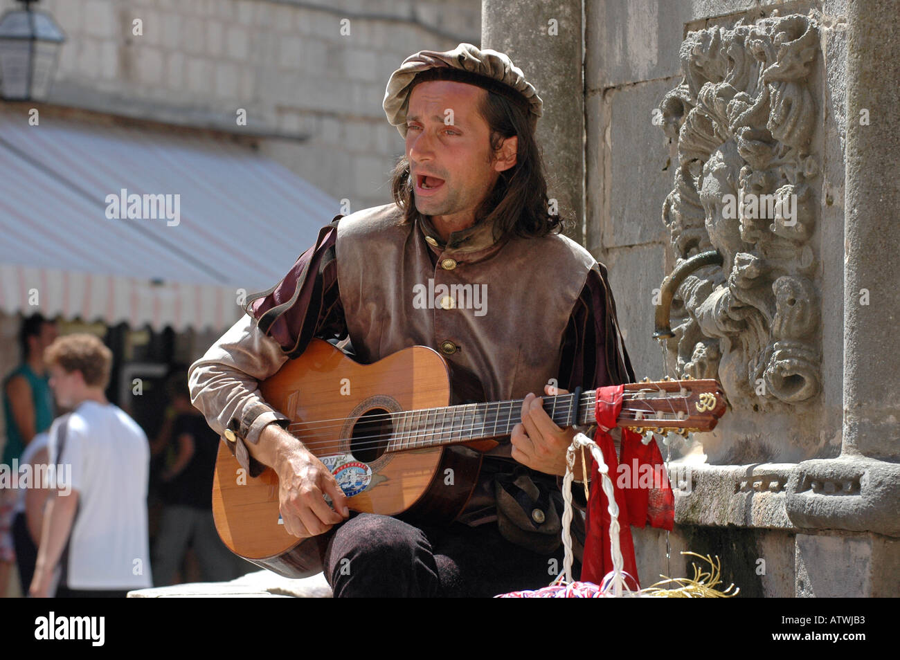 Street busker in traditional Croatian costume in the old walled city of ...