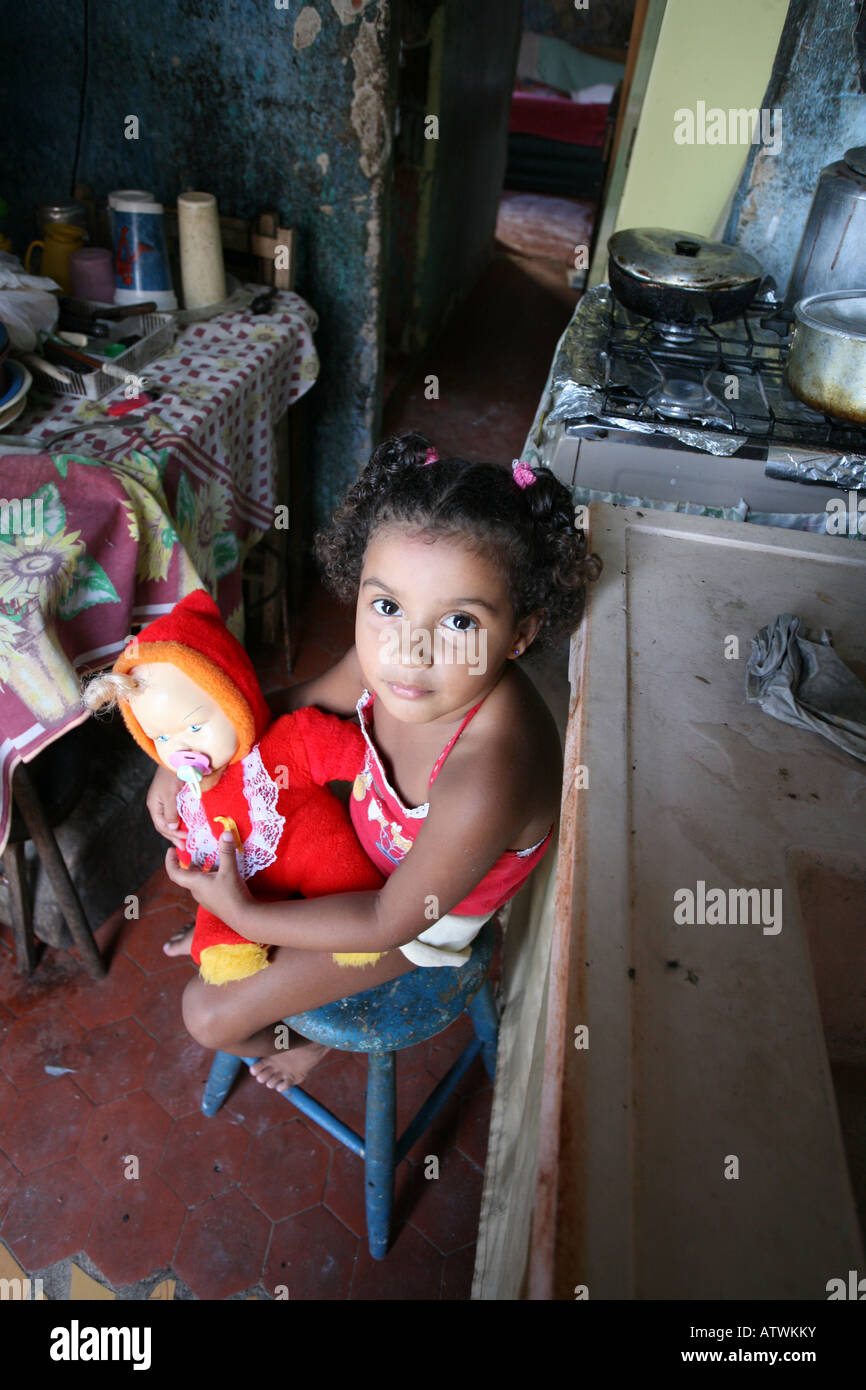 Little girl with doll in derelict kitchen of favela shanty town home ...