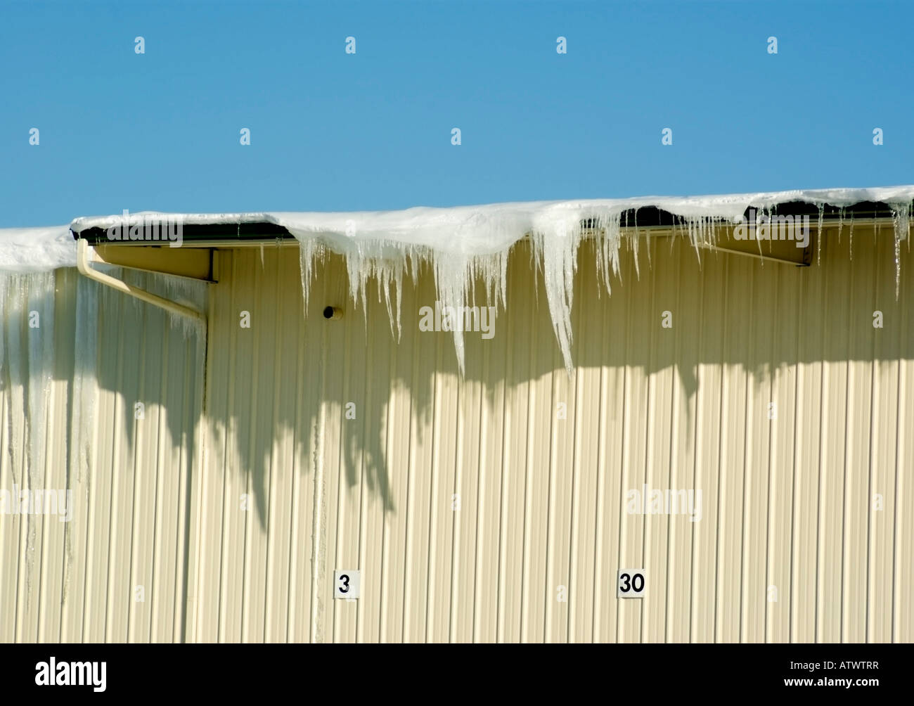 Icicles on eaves of metal building Stock Photo - Alamy