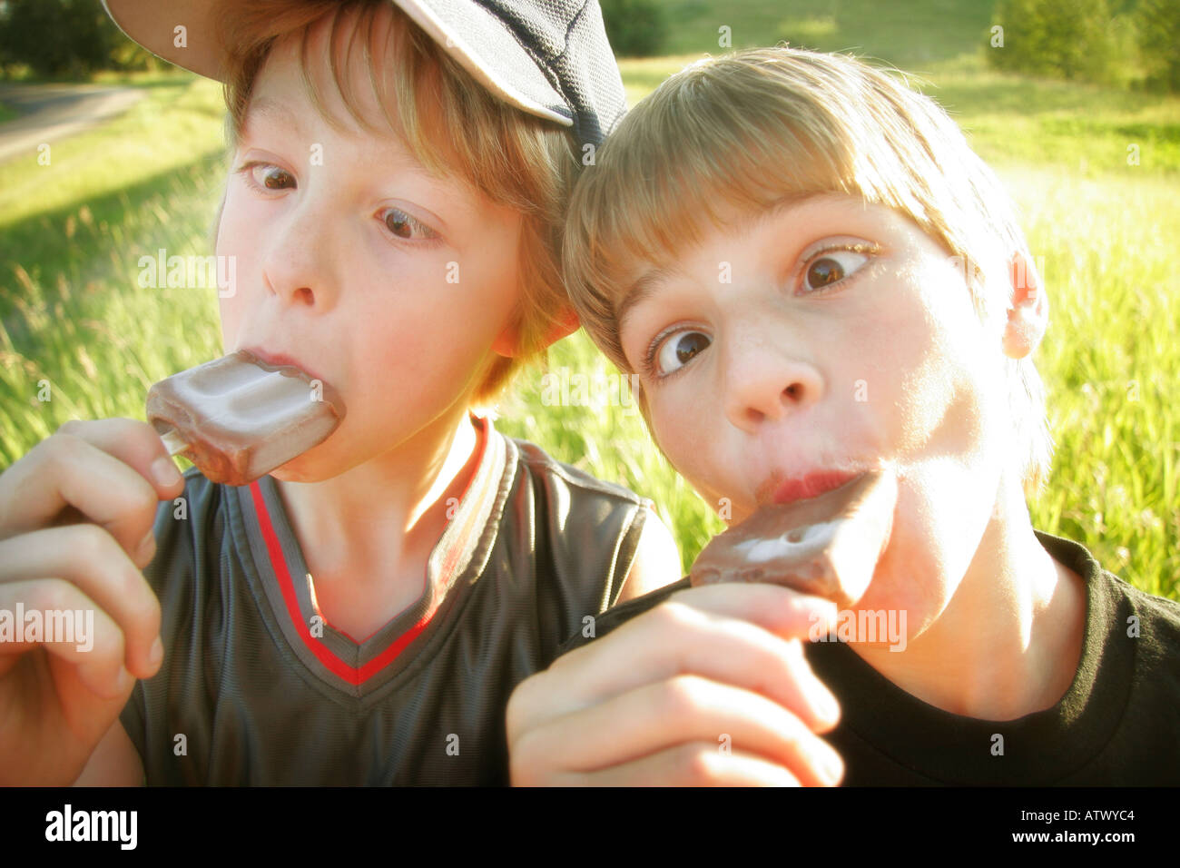 Two boys making funny faces while eating Stock Photo - Alamy
