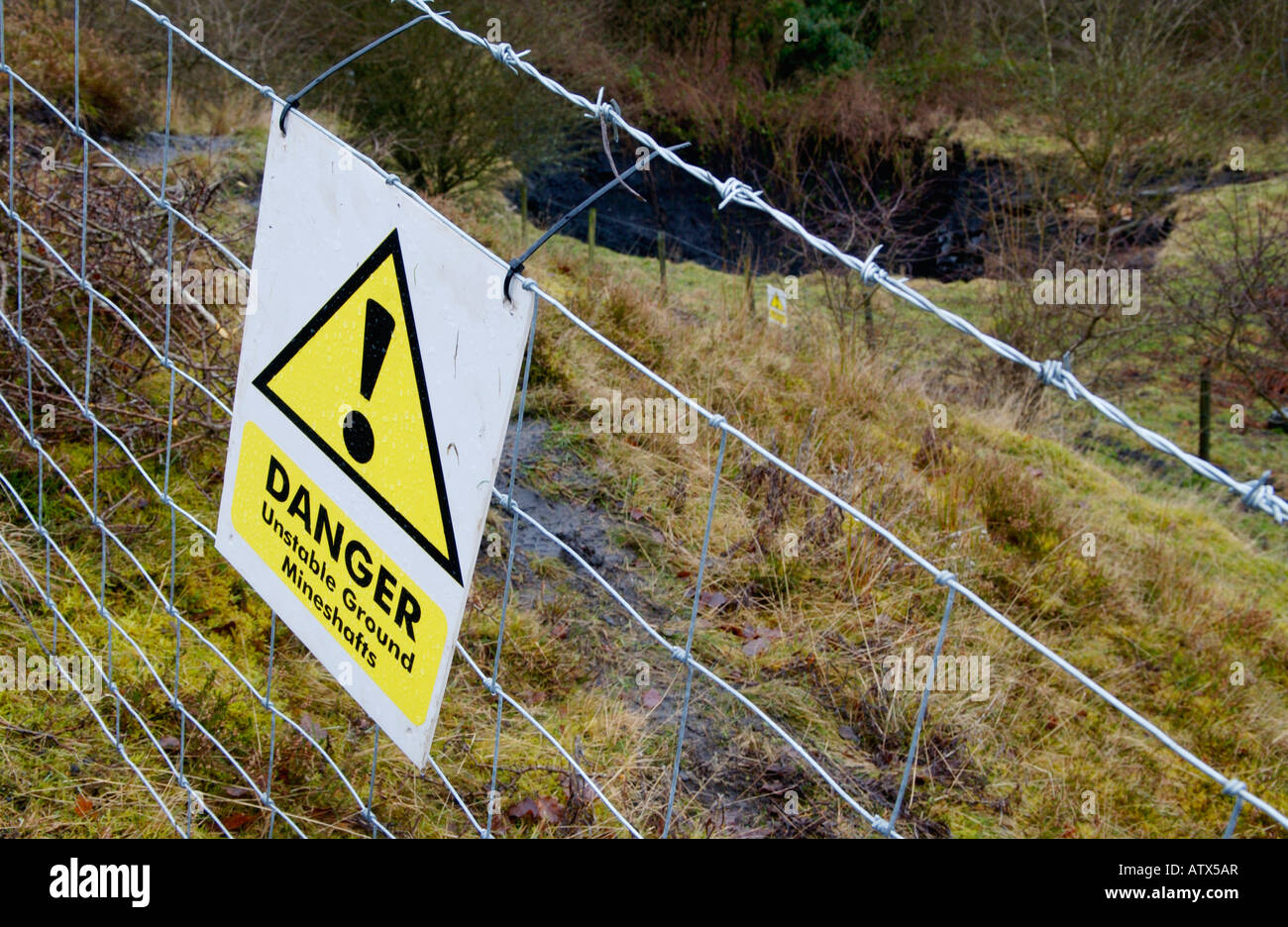 DANGER KEEP OUT sign at collapsed mineshaft on development land at Hoel ...