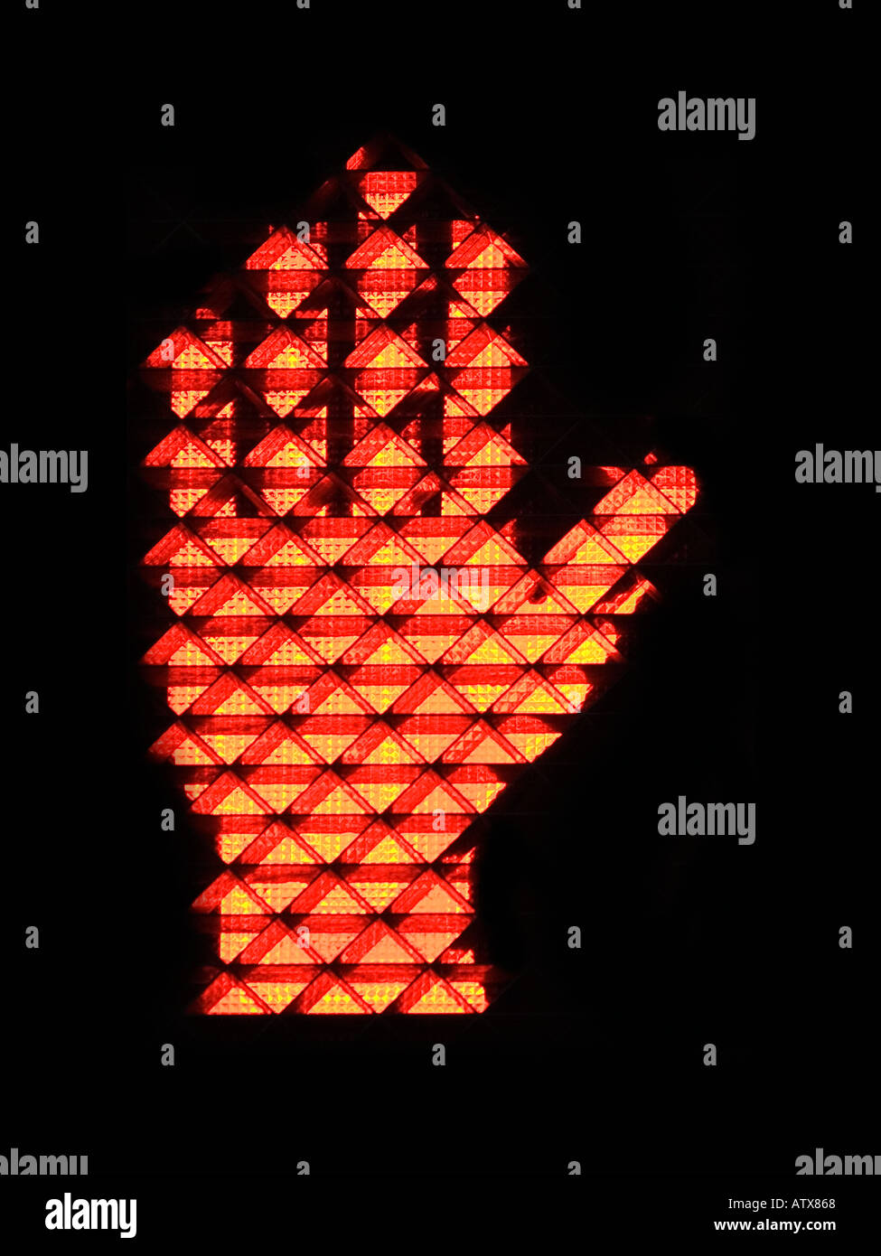 Still life of an orange hand symbolizing a don't walk sign on street ...