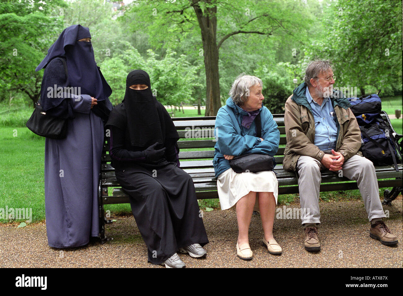 Muslim women sitting on a bench in Hyde Park London alongside an ...