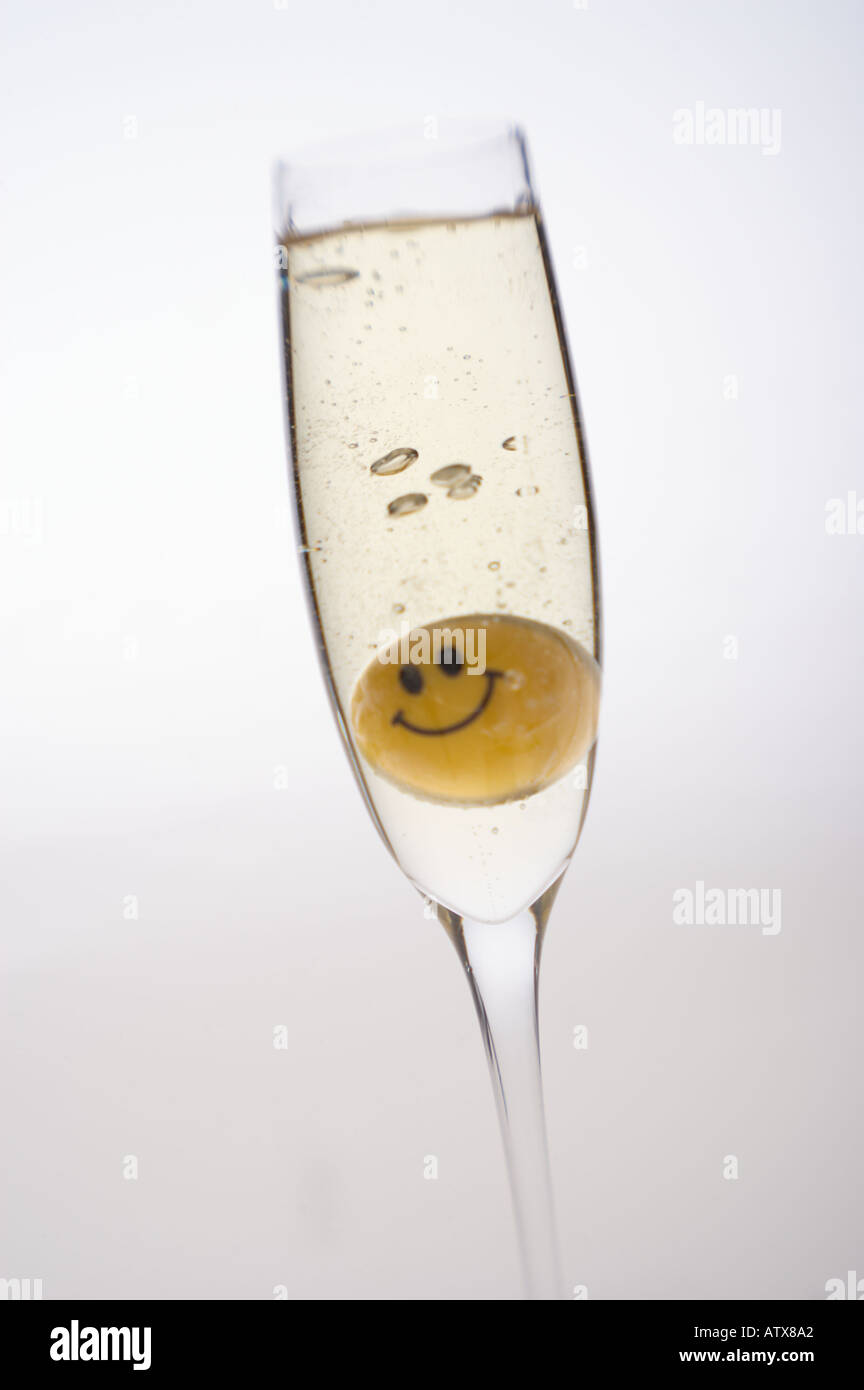 Still life of a glass of champagne with a happy face ball inside On a ...