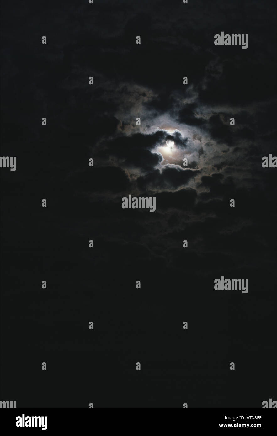 Mysterious full moon seen through hazy sky and partially surrounded by ...