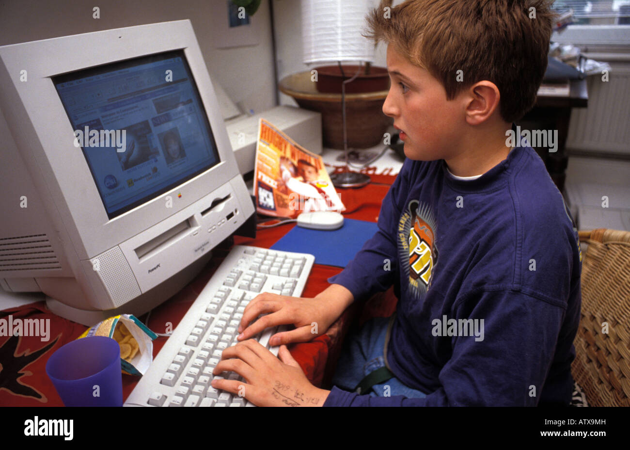 Young boy using computer at home to do homework Stock Photo - Alamy